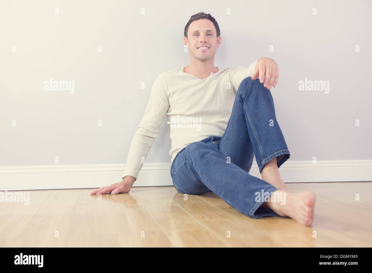 Casual cheerful man leaning against wall looking at camera Stock Photo ...