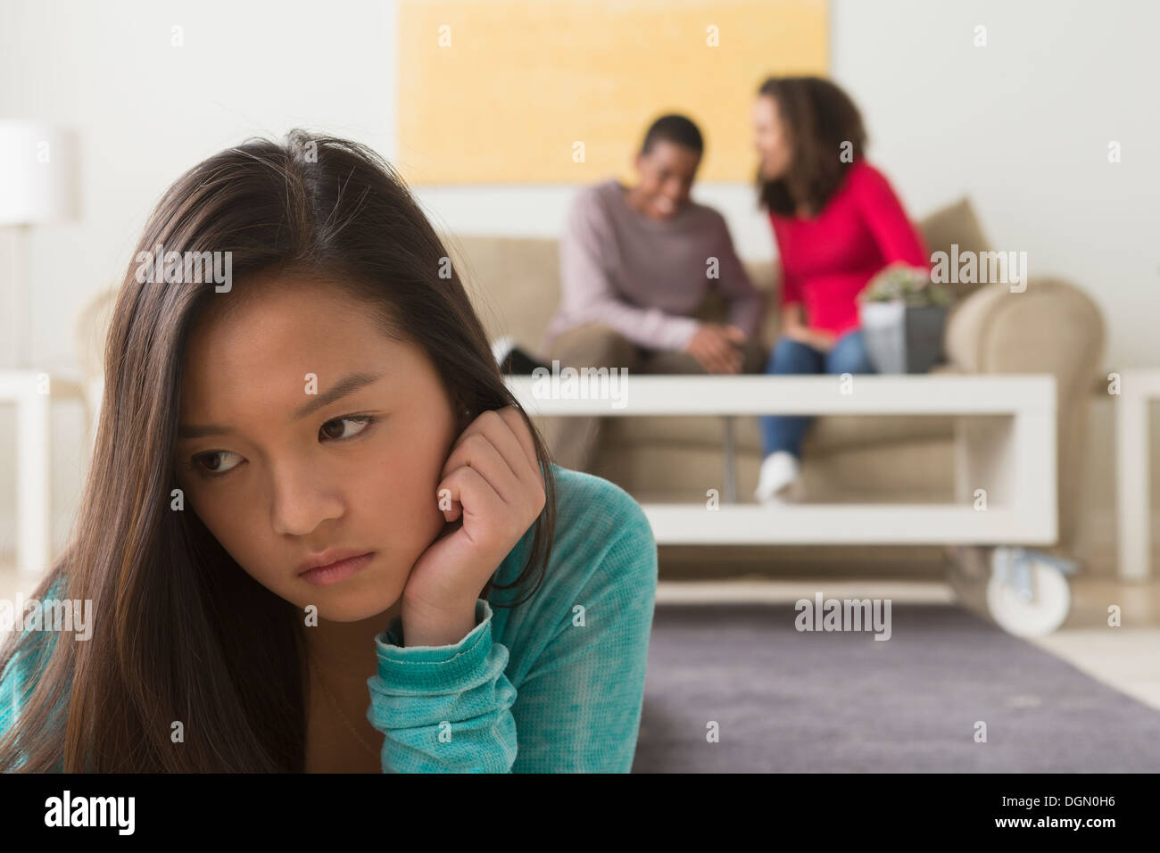 Teenage girl (16-17) crying while two friends (12-13,14-15) whispering ...