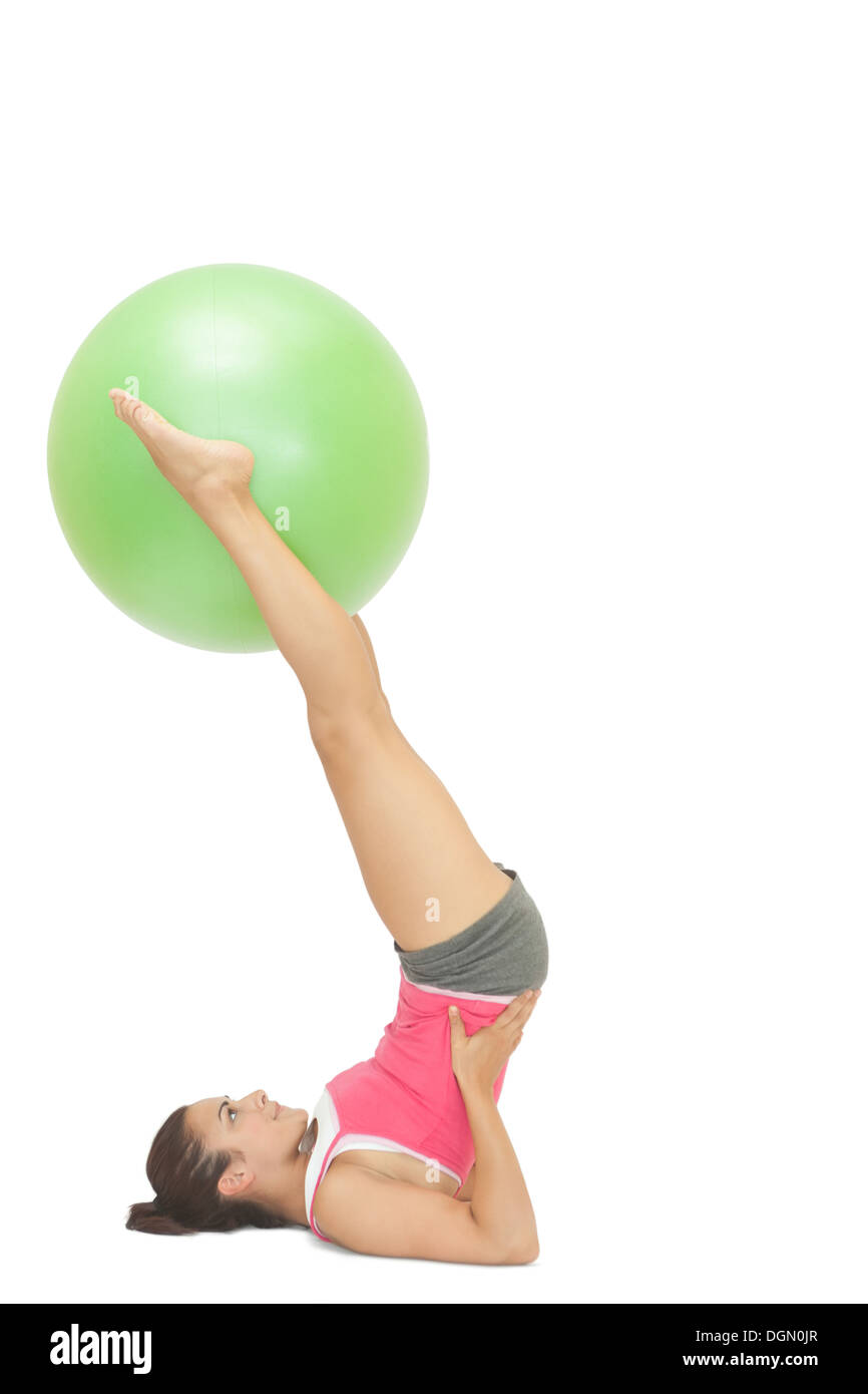 Content sporty brunette holding exercise ball between legs Stock Photo ...