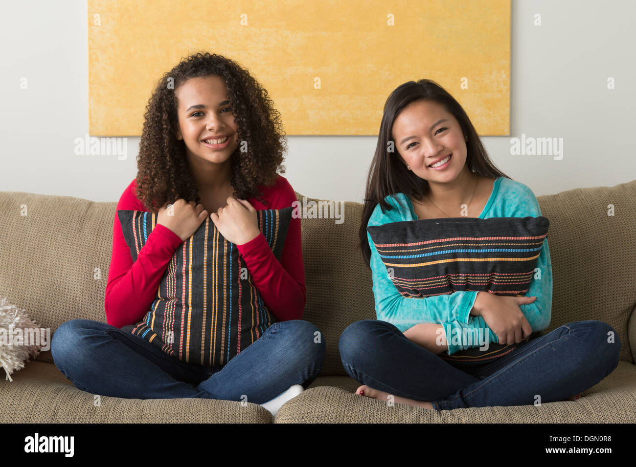 Two friends (12-13,16-17) sitting on sofa Stock Photo - Alamy