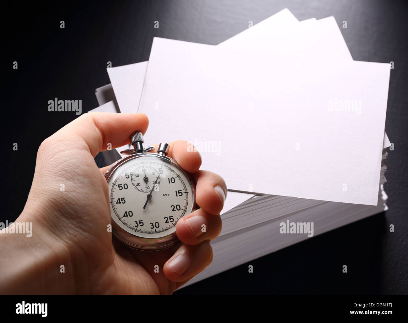 Paper cards on black and hand with stopwatch Stock Photo - Alamy