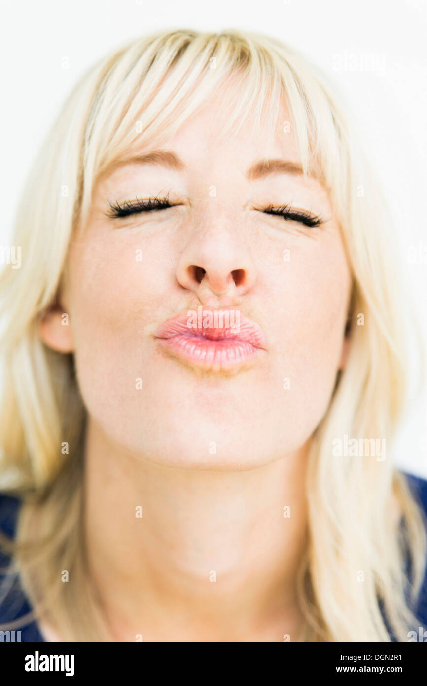 Studio portrait of blonde woman puckering Stock Photo - Alamy