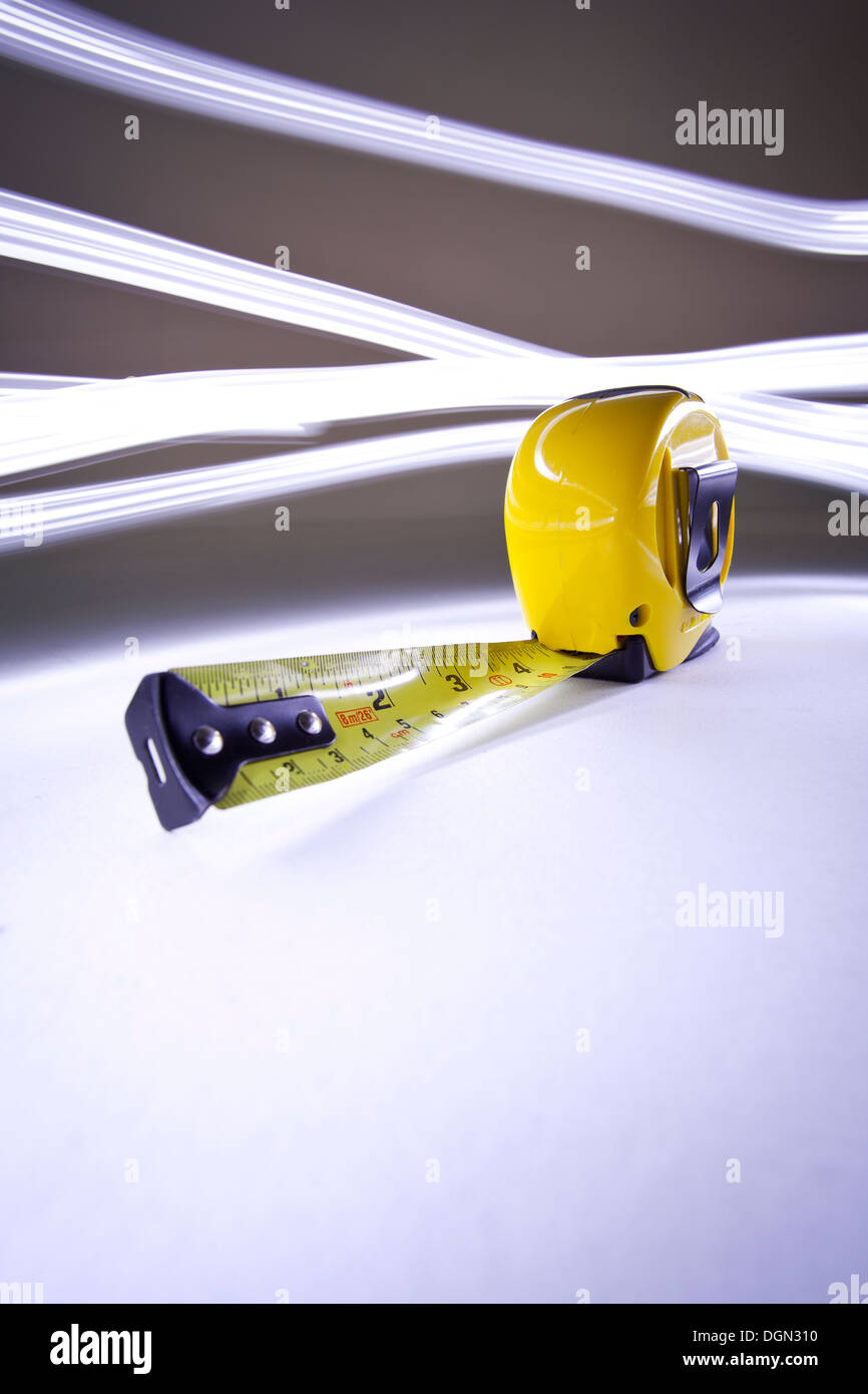 Bright yellow tape measure with light streaks Stock Photo - Alamy