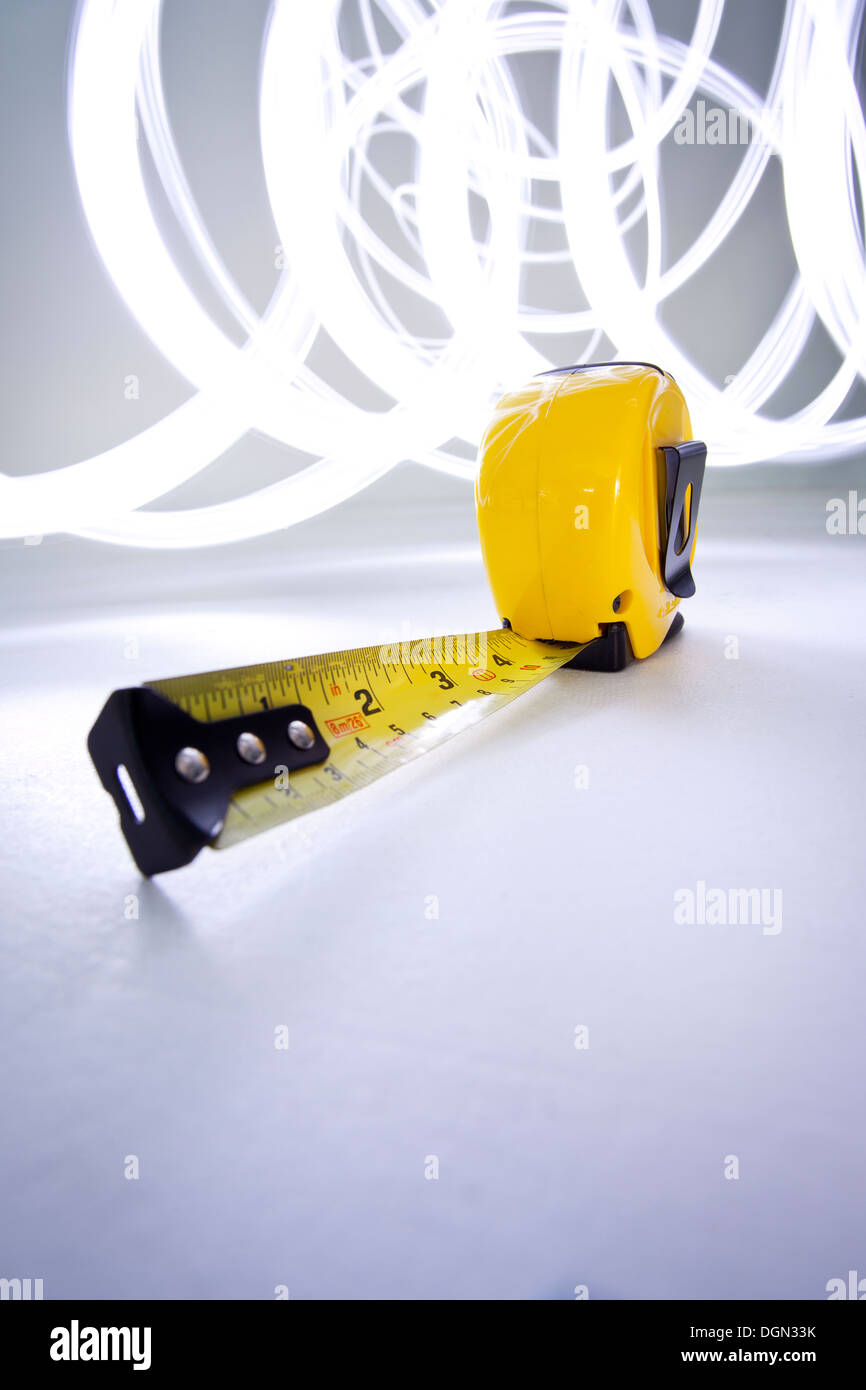 Bright yellow tape measure with light streaks Stock Photo - Alamy