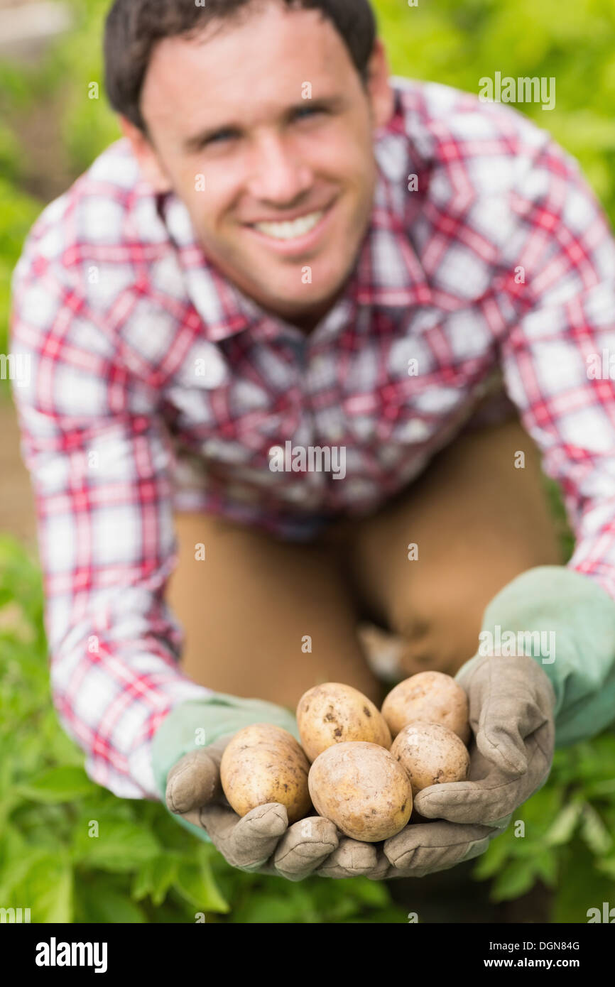 Young man showing some potatoes Stock Photo - Alamy
