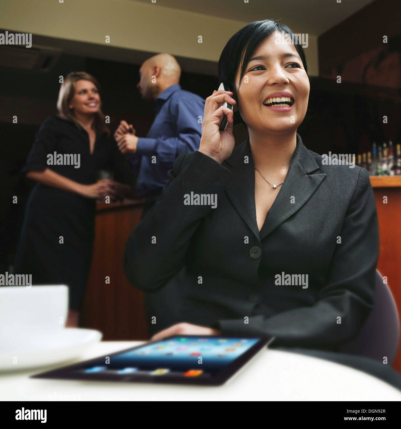 A young woman sitting in a hotel bar speaking on a mobile phone Stock ...