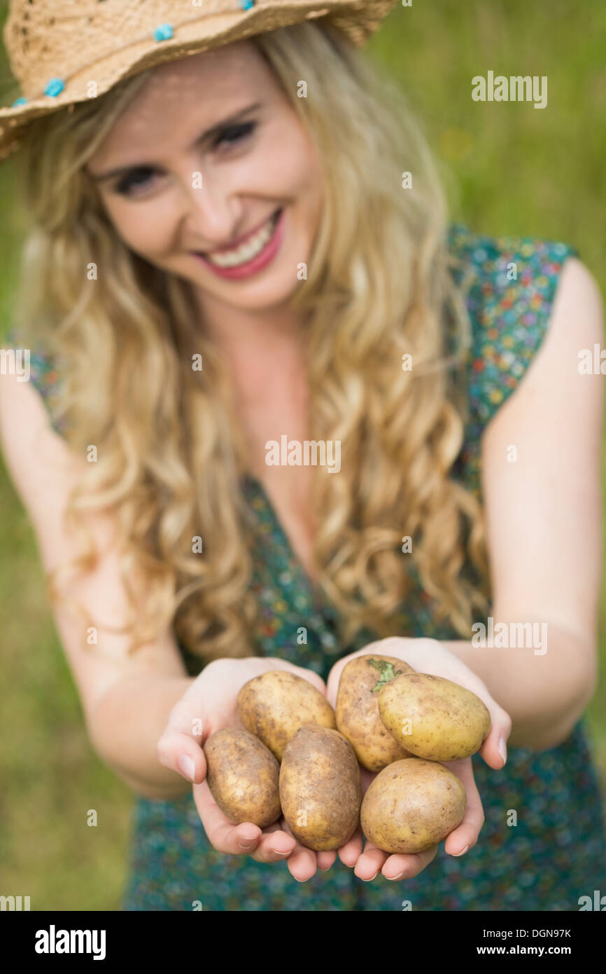 Blonde young woman handing some potatoes Stock Photo - Alamy