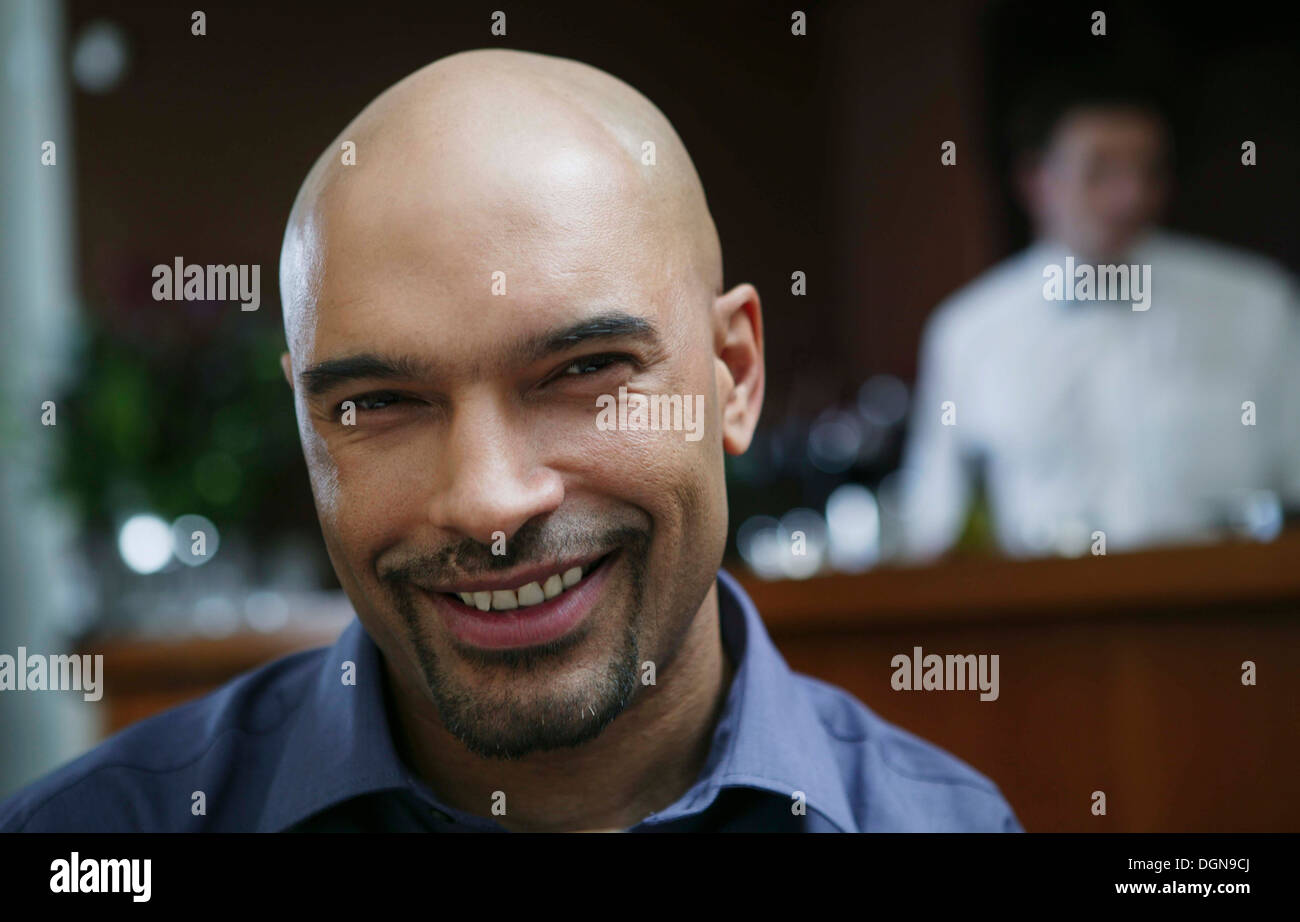 A young man sitting in a hotel bar, smiling Stock Photo - Alamy
