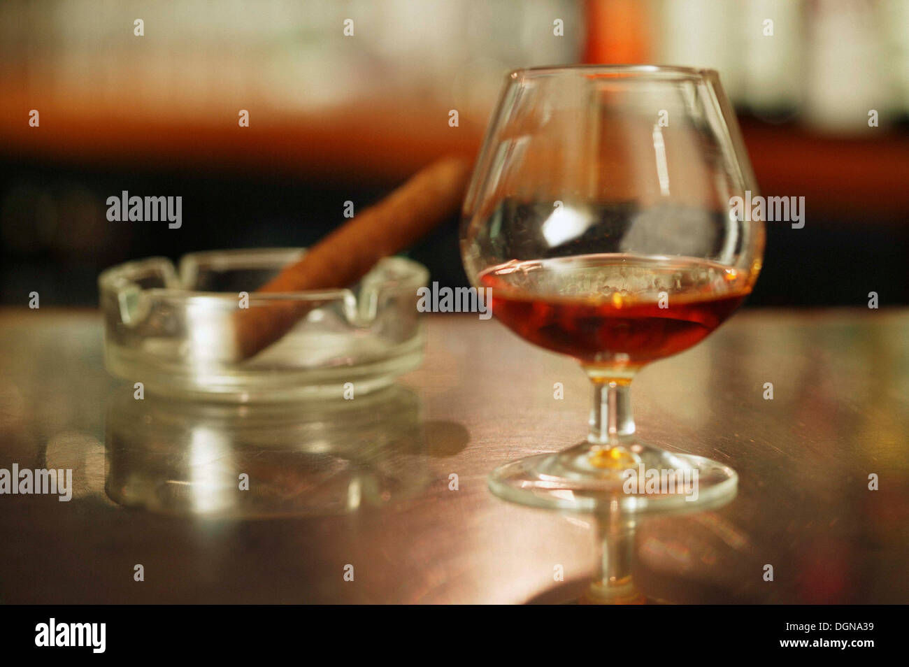 A glass of brandy and a cigar on a bar Stock Photo - Alamy