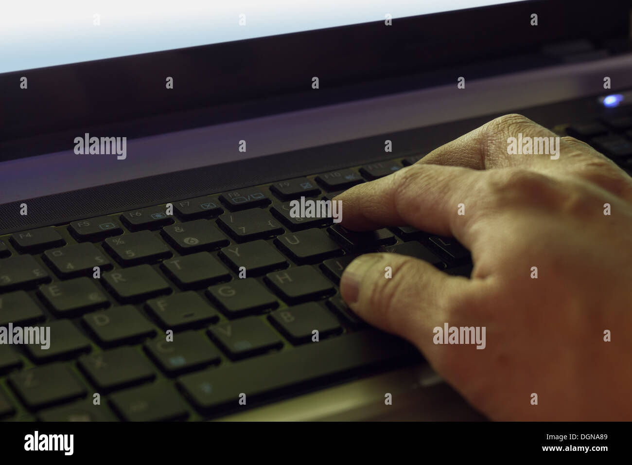 Hand typing on a laptop's keyboard Stock Photo - Alamy