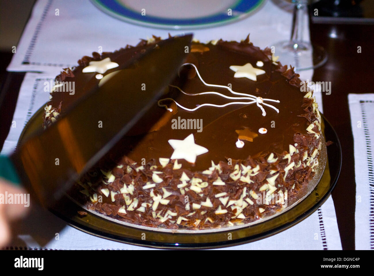 Hand cutting a cake with decoration Stock Photo - Alamy