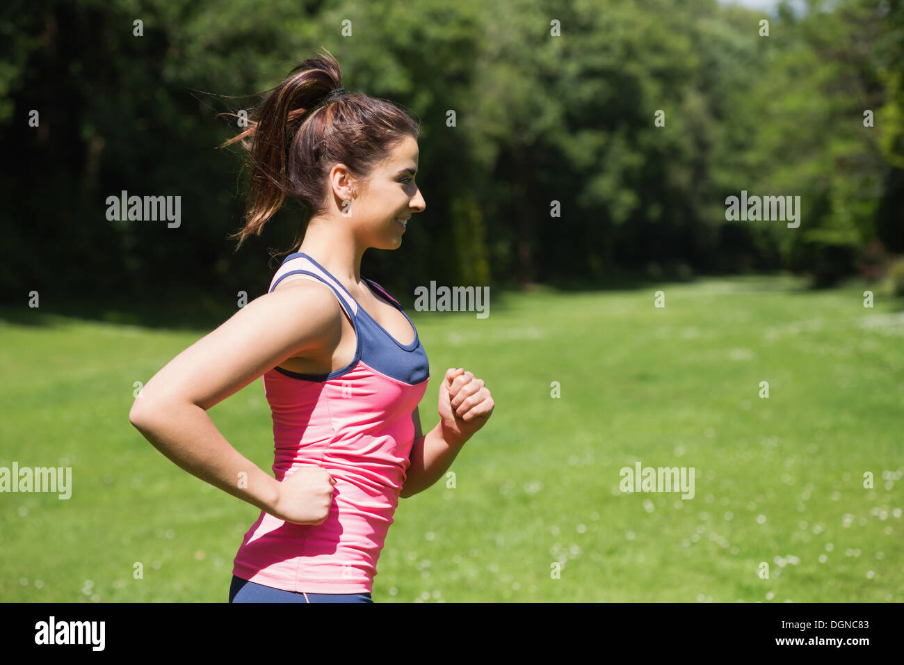 Fit woman running in the sunshine and smiling Stock Photo - Alamy