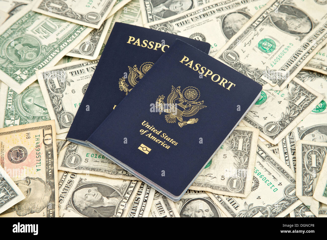 Two American passports laying on a pile of money Stock Photo - Alamy