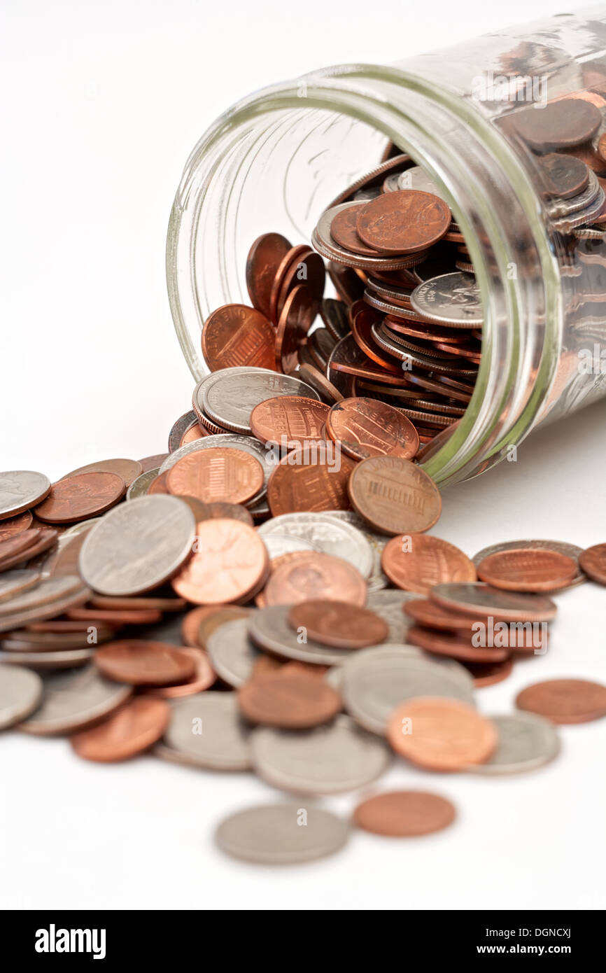 Loose change pouring out of a glass mason jar Stock Photo - Alamy
