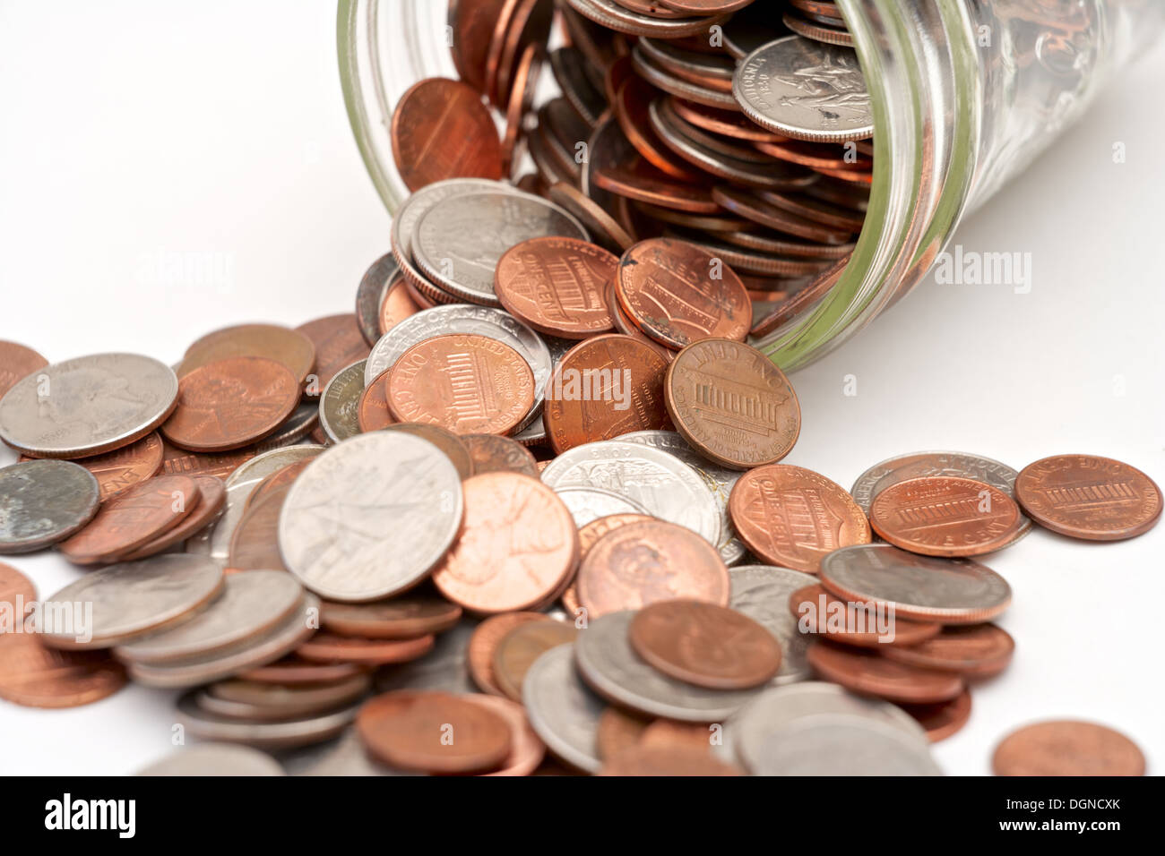 Loose change pouring out of a glass mason jar Stock Photo - Alamy