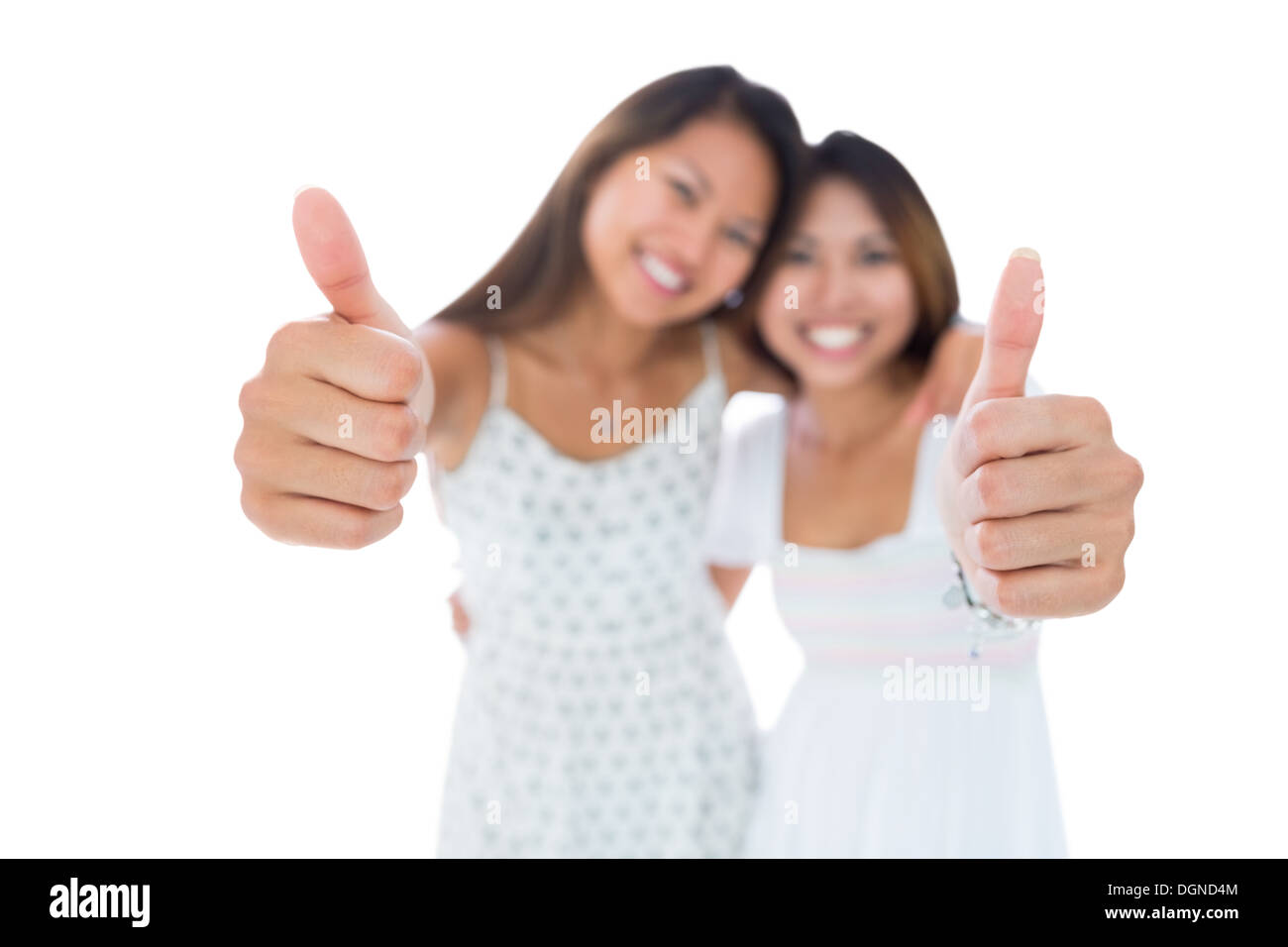 Two pretty young women showing thumbs up Stock Photo - Alamy