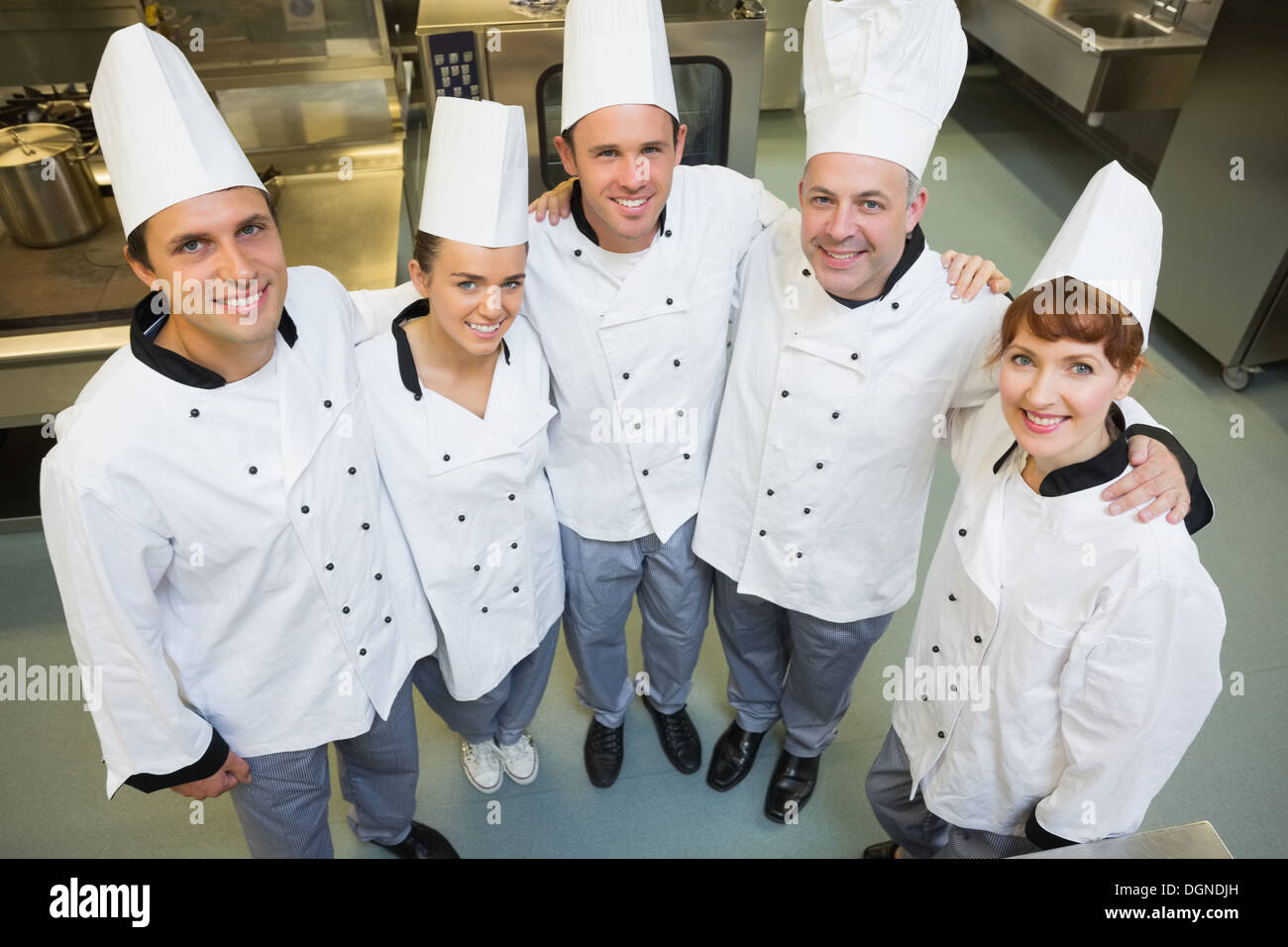 Five happy chefs smiling up at the camera Stock Photo - Alamy