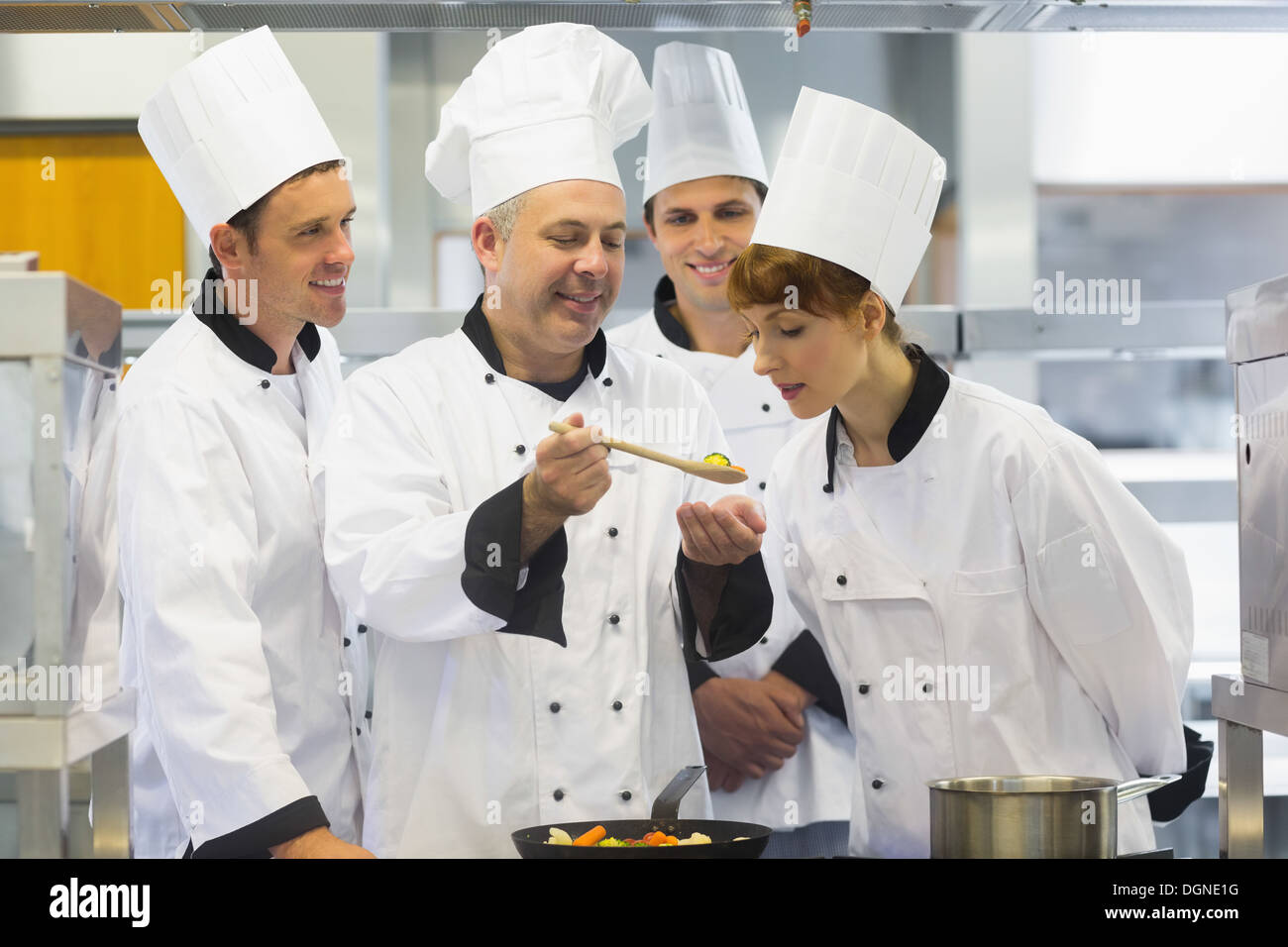 Senior chef showing food to his colleagues Stock Photo - Alamy