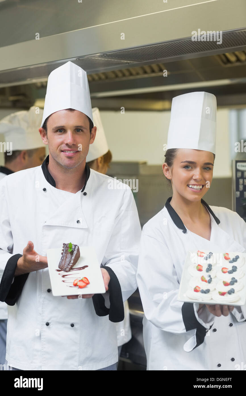 Two happy chefs presenting dessert plates Stock Photo - Alamy