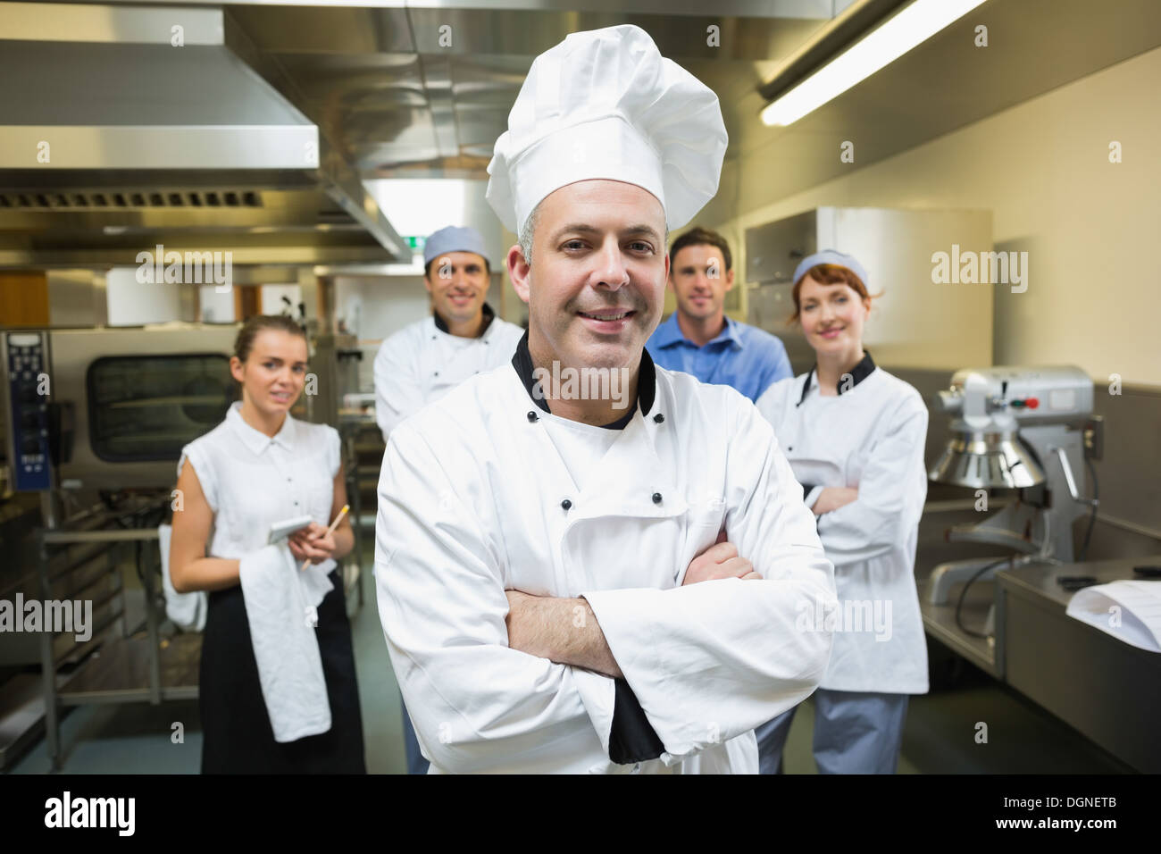 Head chef posing with team behind him Stock Photo - Alamy