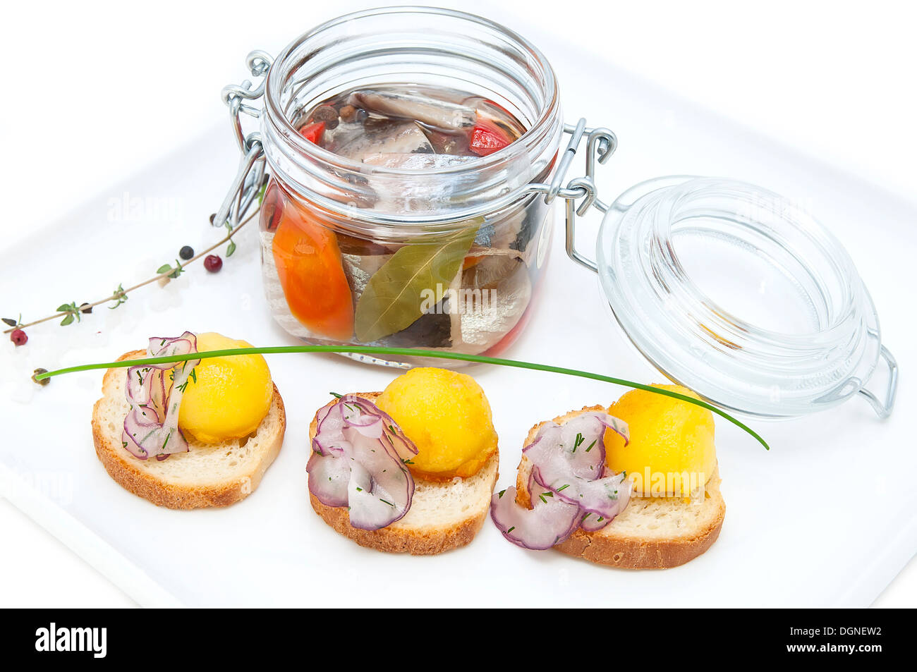 pickled herring in a glass jar with potato canapes Stock Photo - Alamy