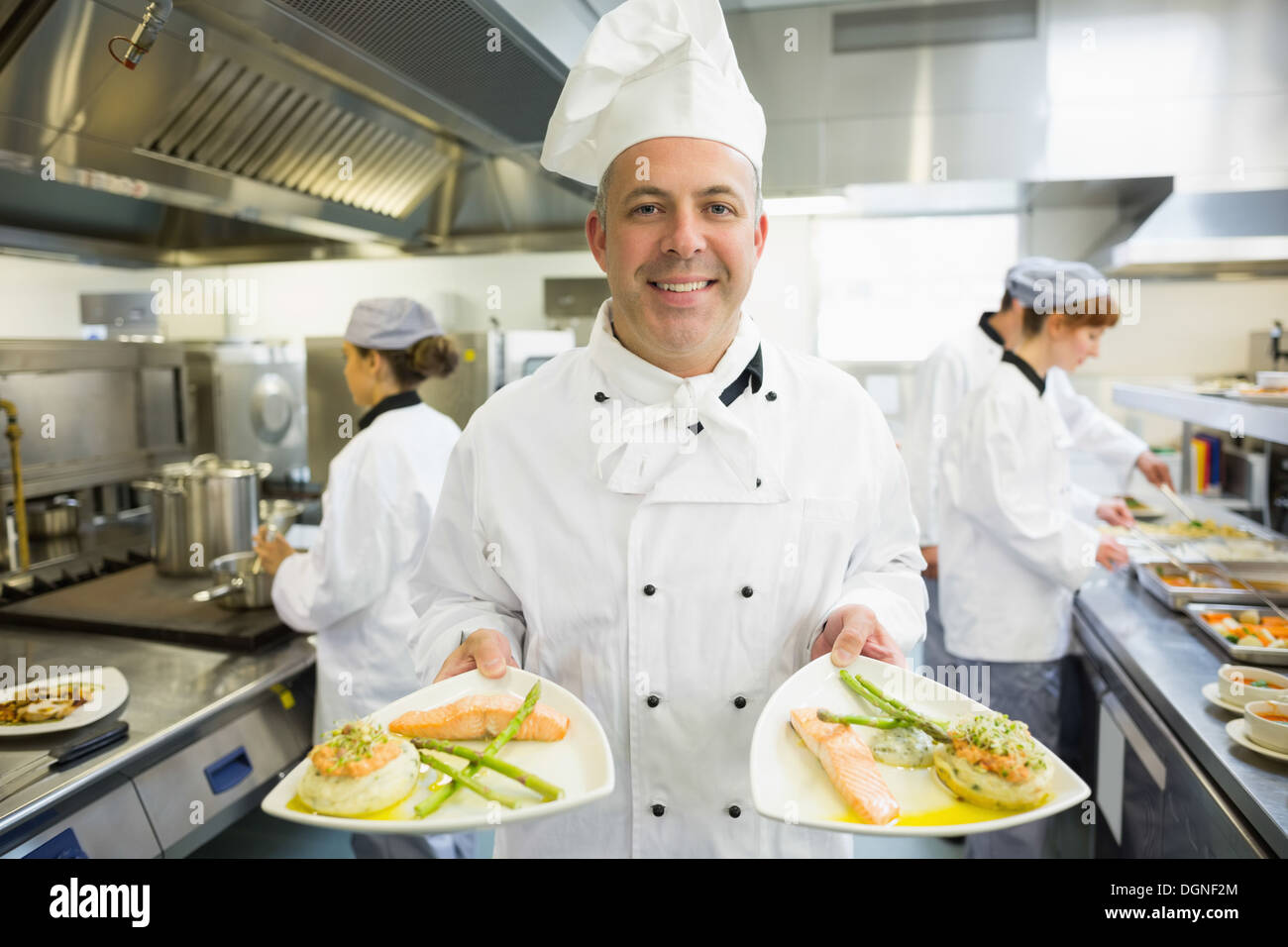 Mature head chef presenting proudly some dinner plates Stock Photo - Alamy