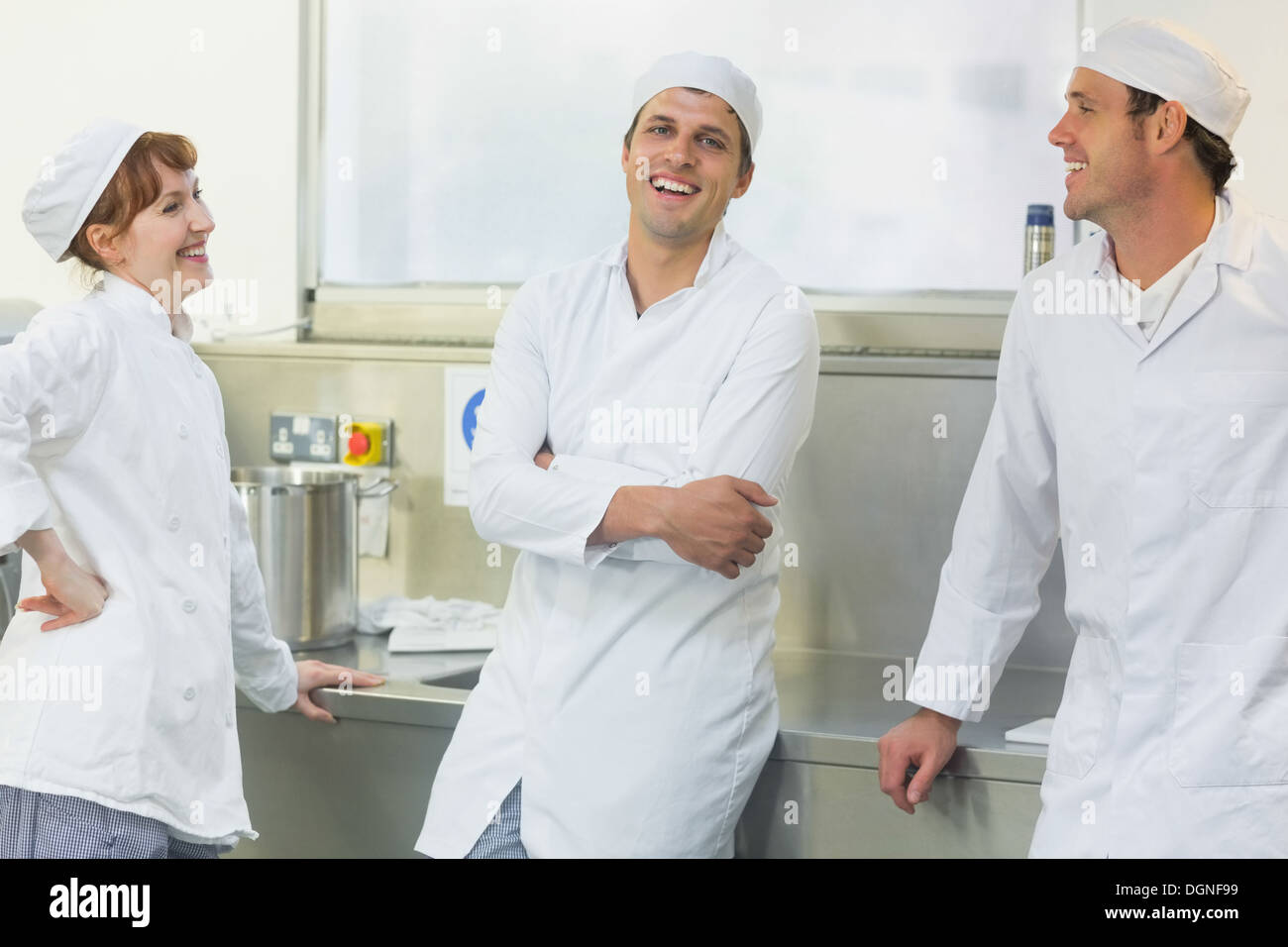 Three chatting bakers standing in a bakery Stock Photo - Alamy