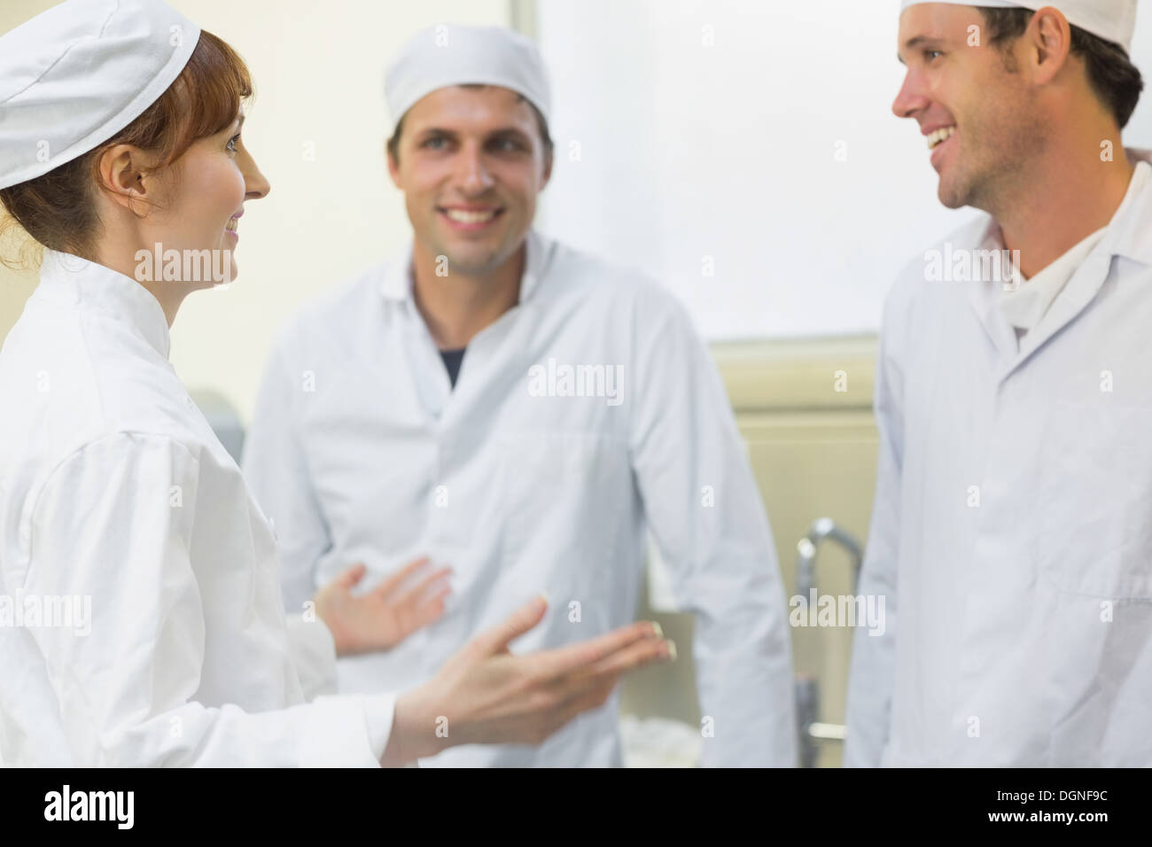 Young female baker talking to her colleagues Stock Photo - Alamy