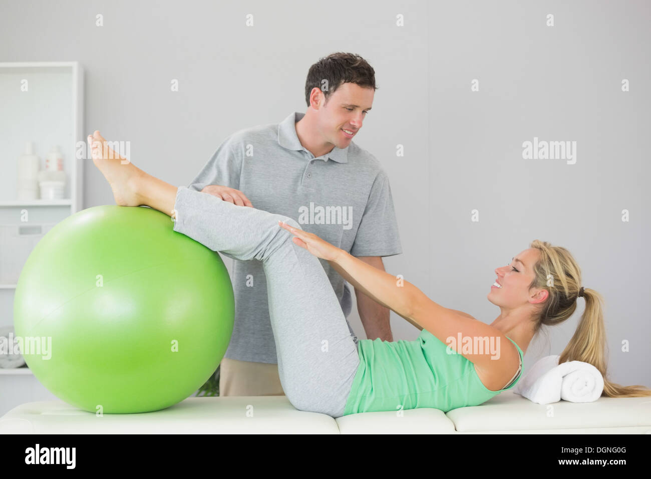 Patient holding exercise ball with legs Stock Photo - Alamy