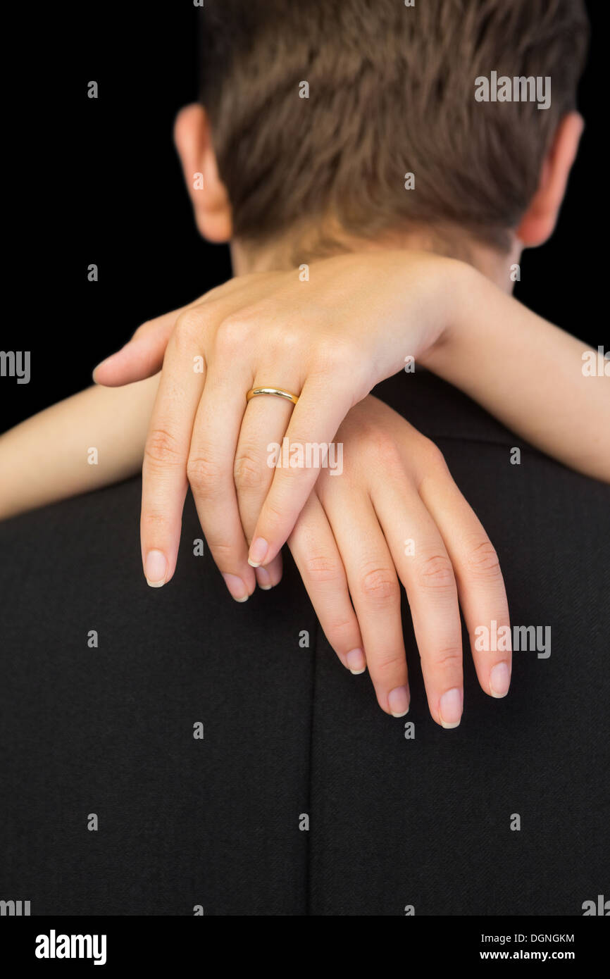 Rear view of young man being embraced by his wife Stock Photo - Alamy