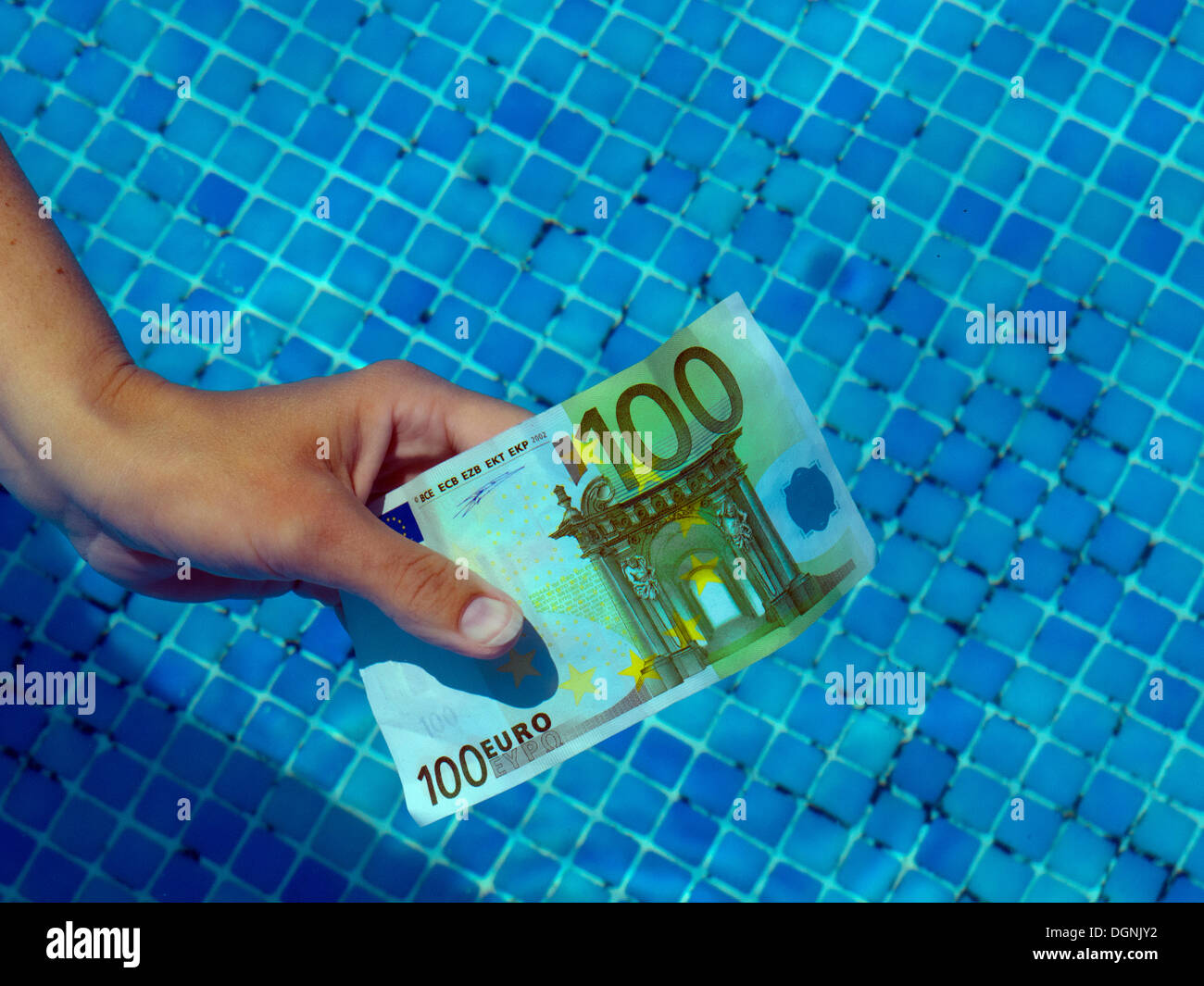 Hand with euro note in a pool, symbolic image for the sinking of the ...