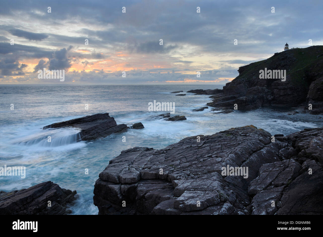 Coastal cliffs and rocks with a lighthouse on the Atlantic Ocean in the ...