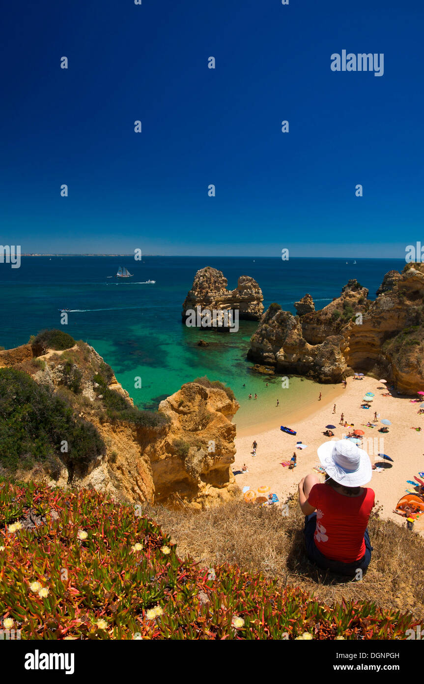 Tourist overlooking the bay of Praia do Camilo, Algarve, Portugal ...