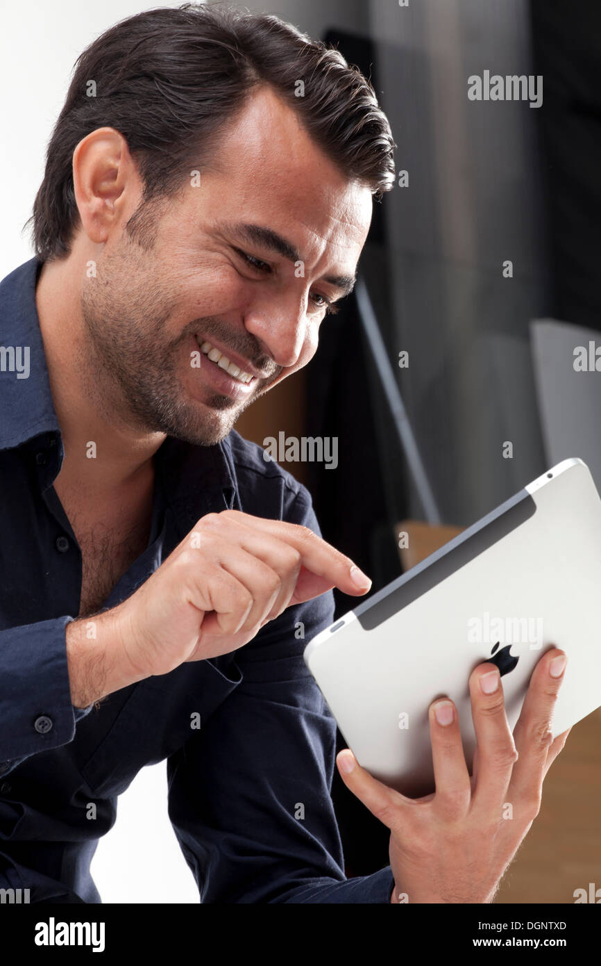 Smiling man using an iPad Stock Photo - Alamy
