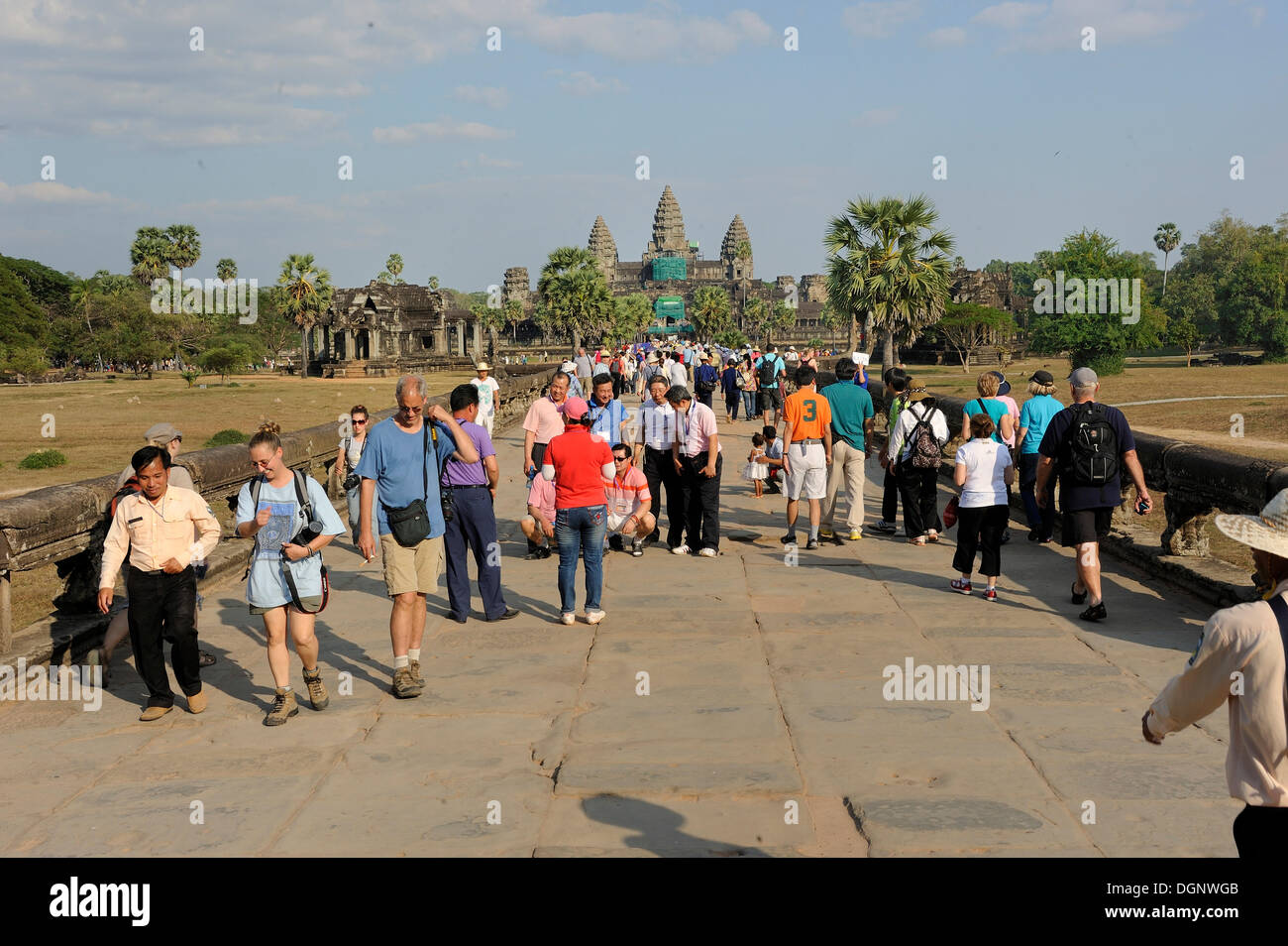 Stream of visitors on the stone dam leading to Angkor Wat, Siam Reap ...