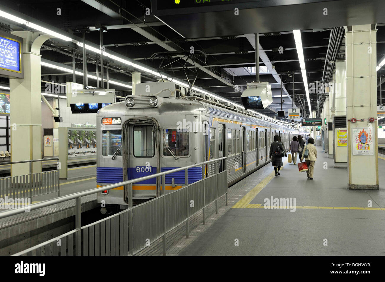 Train from the Nankai Line at the station on a platform with a yellow ...