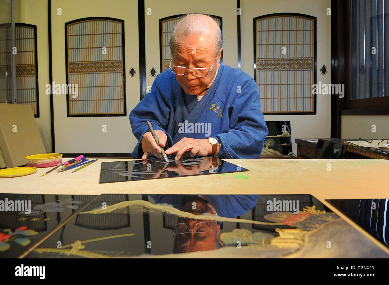 Japanese artisan scraping a bamboo motif onto the top lacquer coat ...