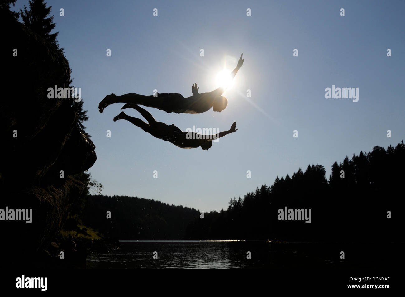 Two men, diving off a cliff, backlit, Kamp, Ottenstein reservoir ...