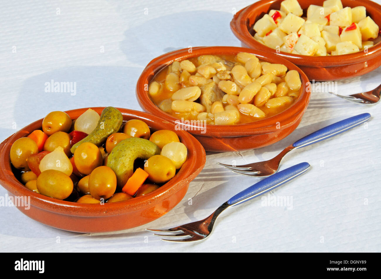 Tapas - From front to back: Green olive cocktail, White beans and pork ...