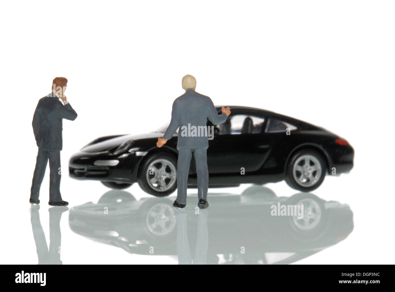 Two business men model figures in front of a car having a conversation ...
