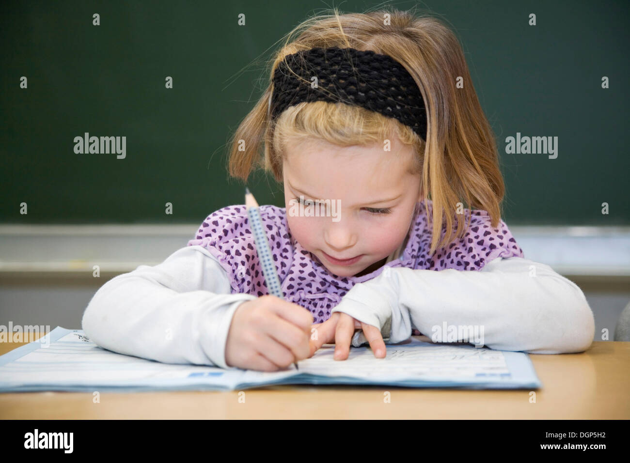 Girls focused on writing during class Stock Photo - Alamy