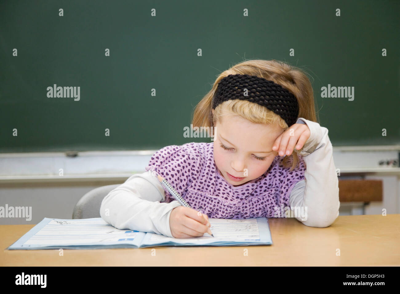 Girls focused on writing during class Stock Photo - Alamy