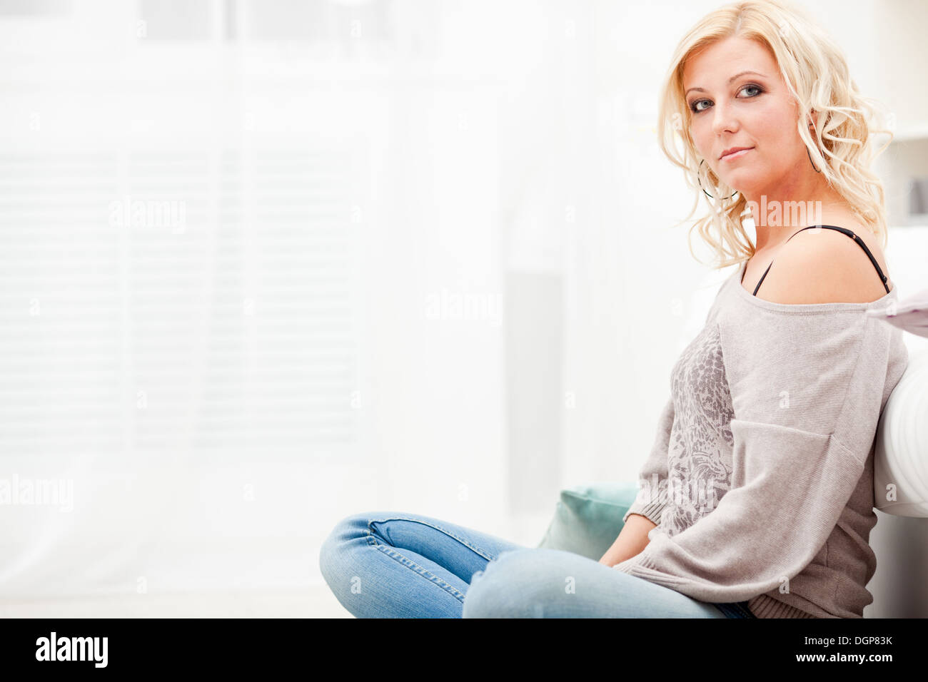 Smiling girl sitting on carpet Stock Photo - Alamy