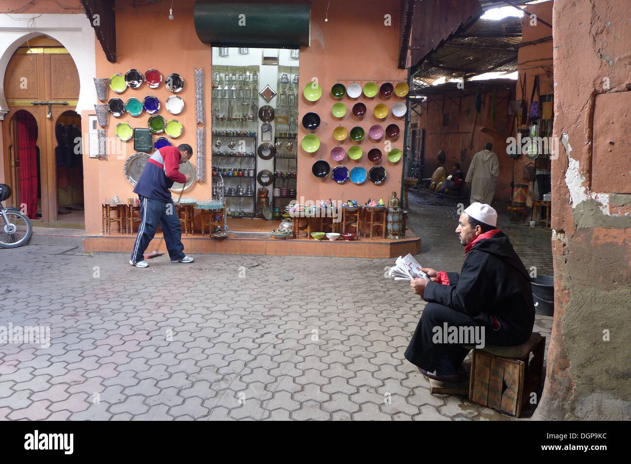 Morocco - Marrakesh street scene, man reading newspaper Stock Photo - Alamy