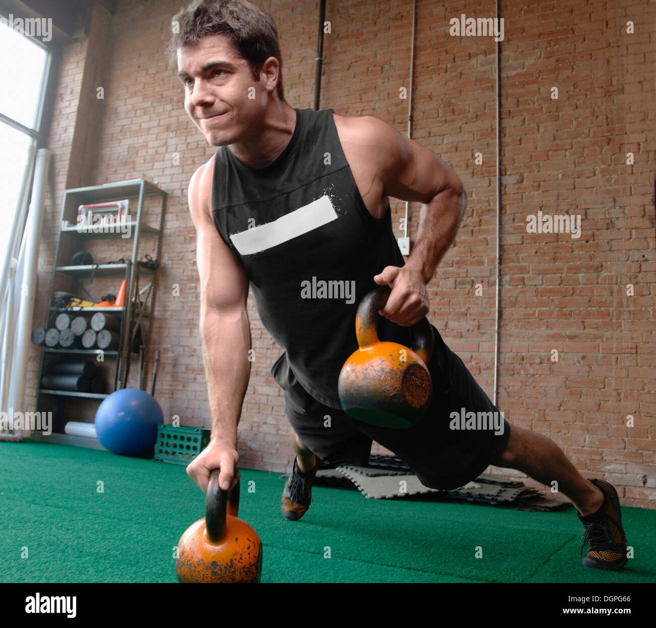 Male bodybuilder lifting kettlebells Stock Photo - Alamy