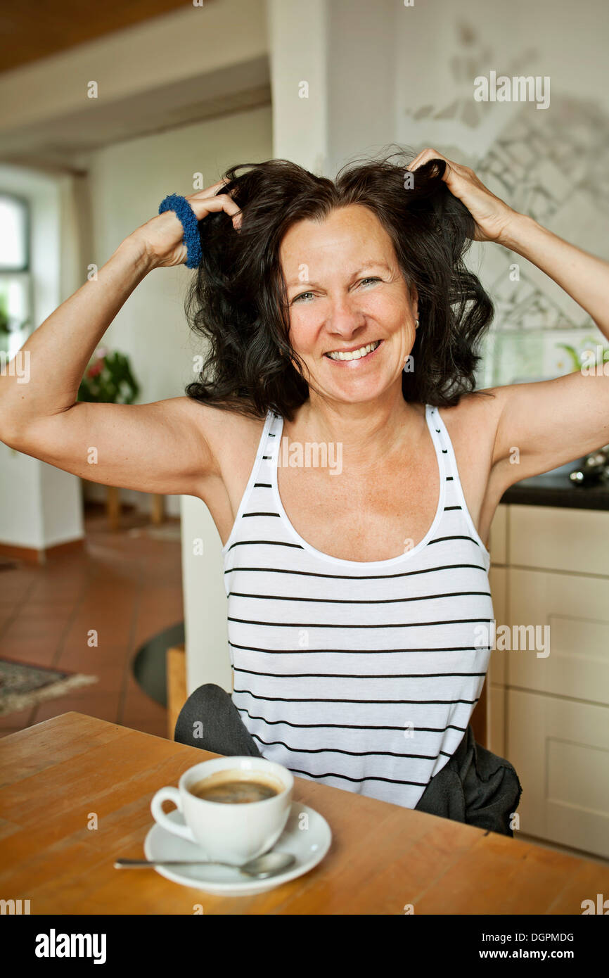 Mature woman running hands through hair hi-res stock photography and ...