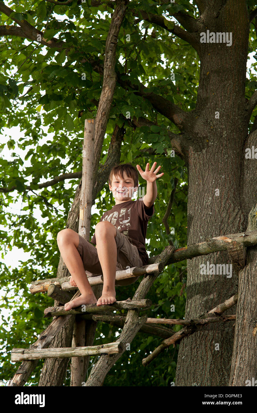 Boy sitting at a tree house Stock Photo - Alamy