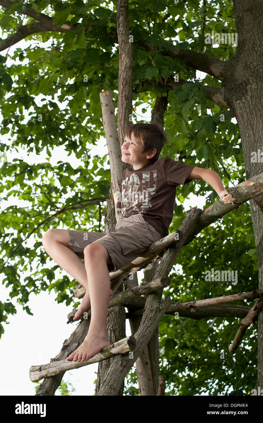 Boy sitting at a tree house Stock Photo - Alamy