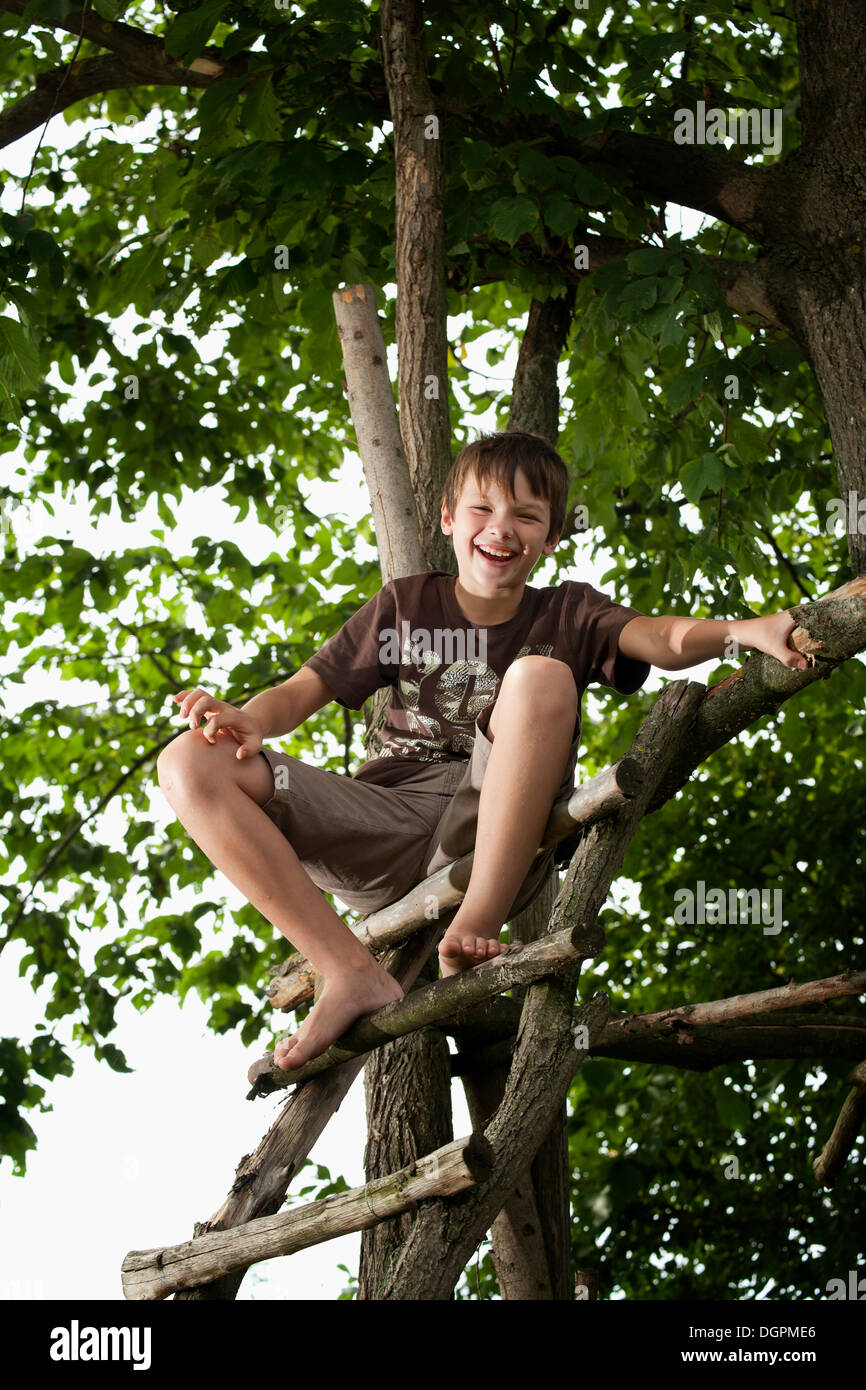 Boy sitting at a tree house Stock Photo - Alamy