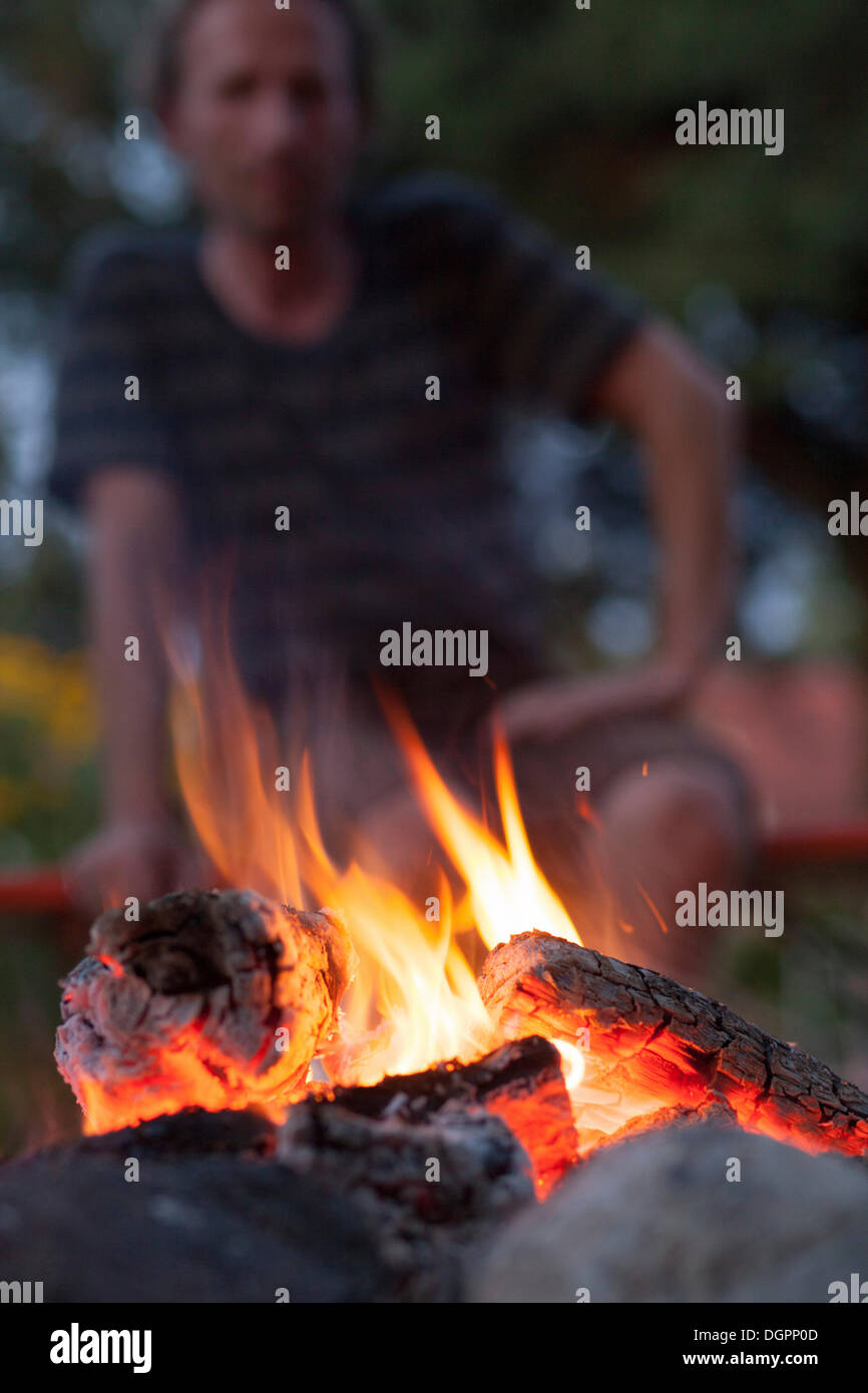 Man sitting behind a fire in a garden Stock Photo - Alamy